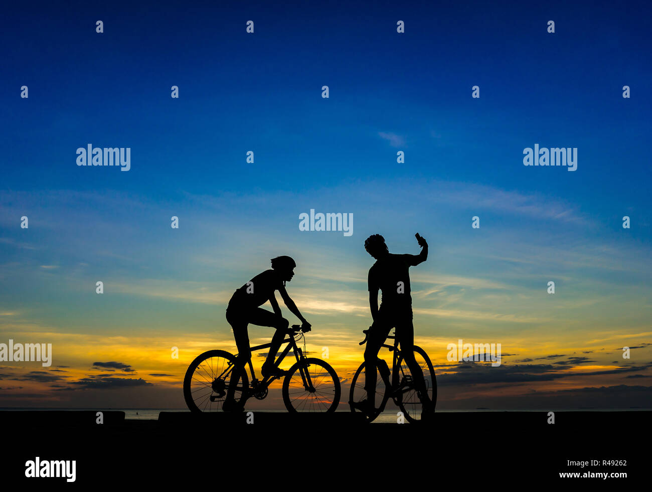 Two Cyclists with their bicycles at the beach, sunset scene Stock Photo ...