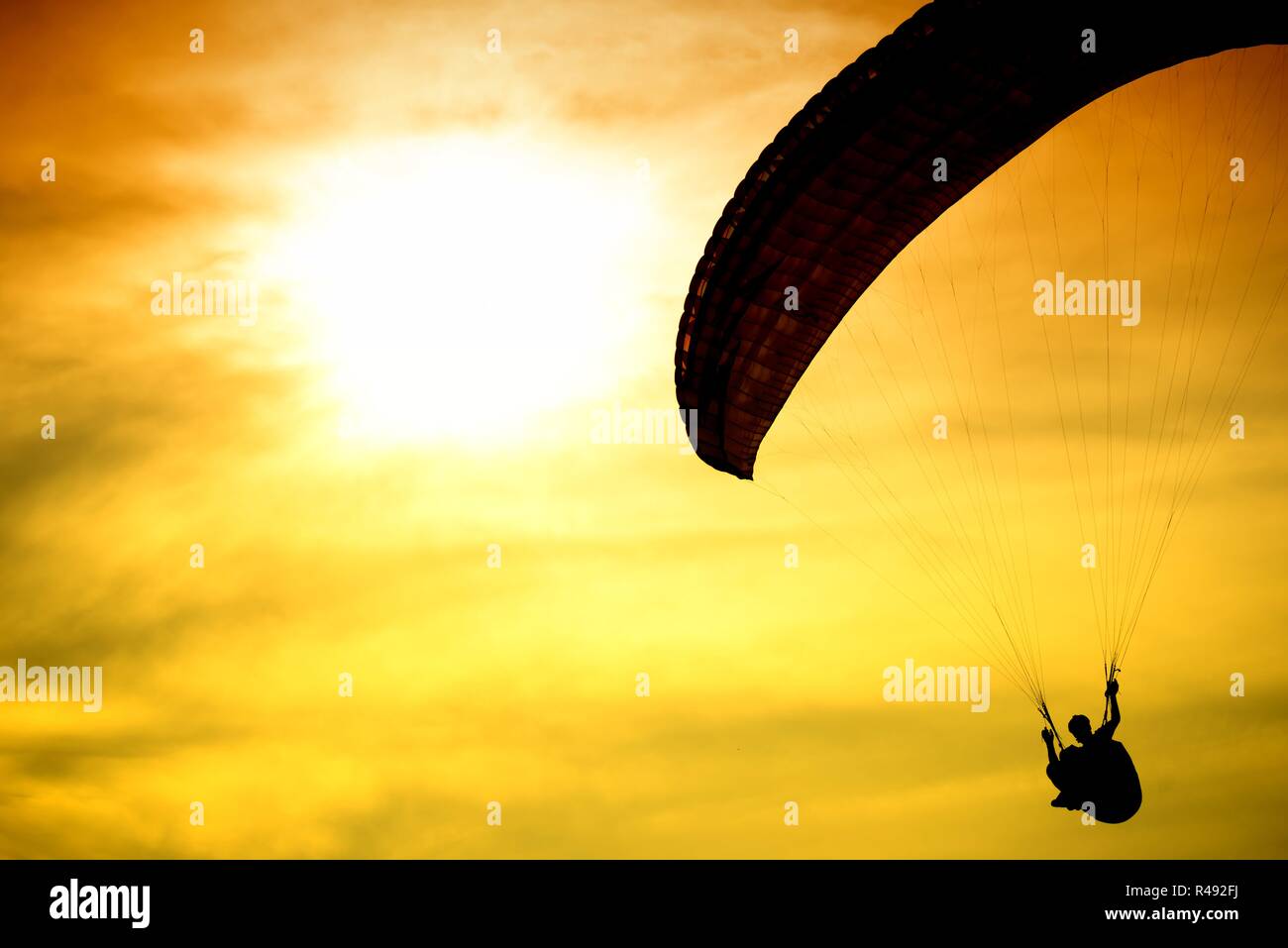 Silhouette of parachute on sunset background Stock Photo - Alamy