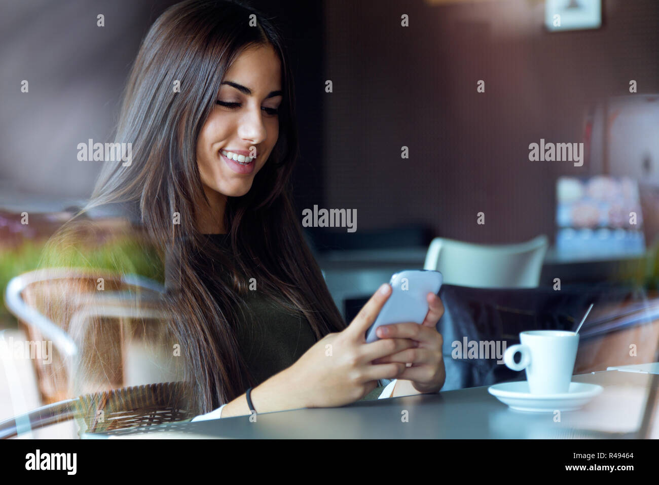 Beautiful girl using her mobile phone in cafe Stock Photo - Alamy