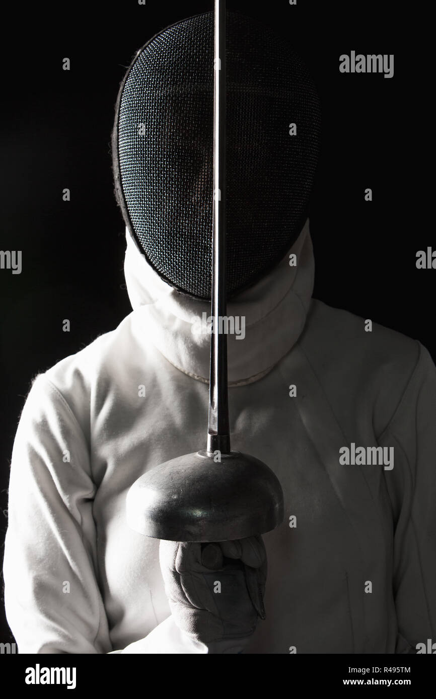 The portrait of woman wearing white fencing costume on black Stock Photo - Alamy