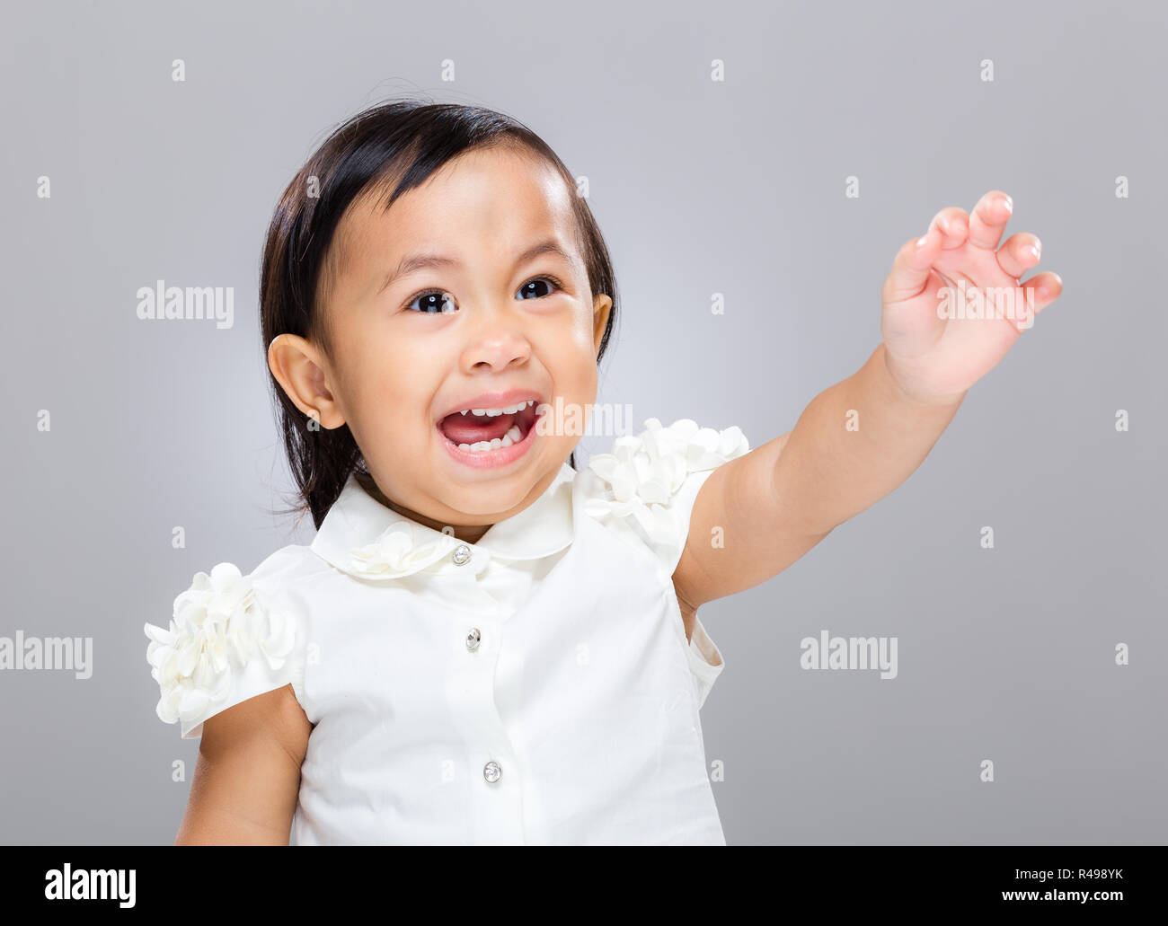 Baby girl excite with hand up Stock Photo - Alamy