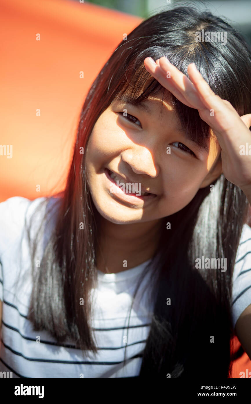 tan skin asian teenager using hand protect sun burned on face skin ...