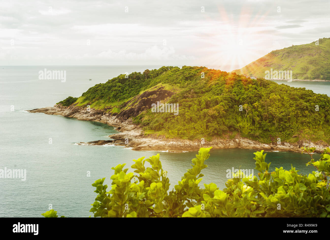 Sea with island in morning light and over light the sun Stock Photo - Alamy