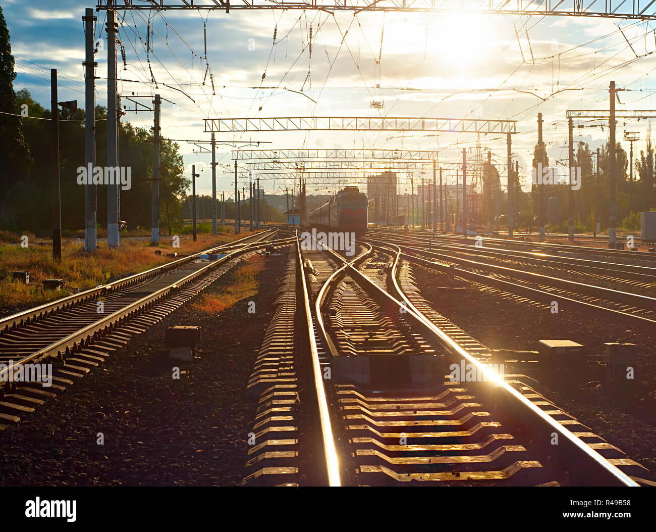 Train on railroad at sunset Stock Photo - Alamy