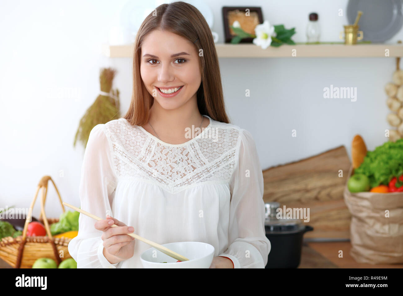 Young happy woman cooking in the kitchen. Healthy meal, lifestyle and ...