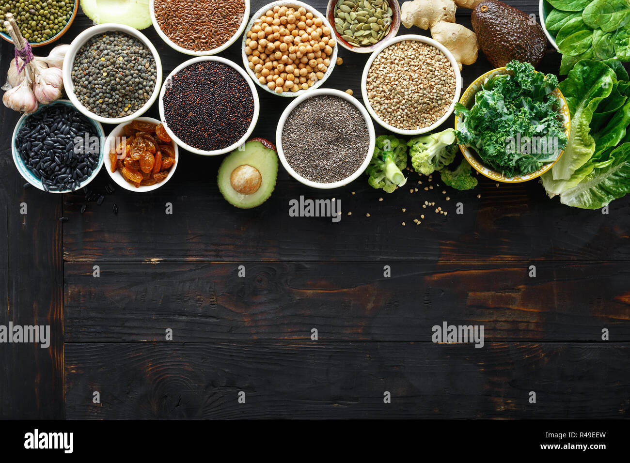 Set superfoods on dark wooden table with copy space. Leaves, cereals ...