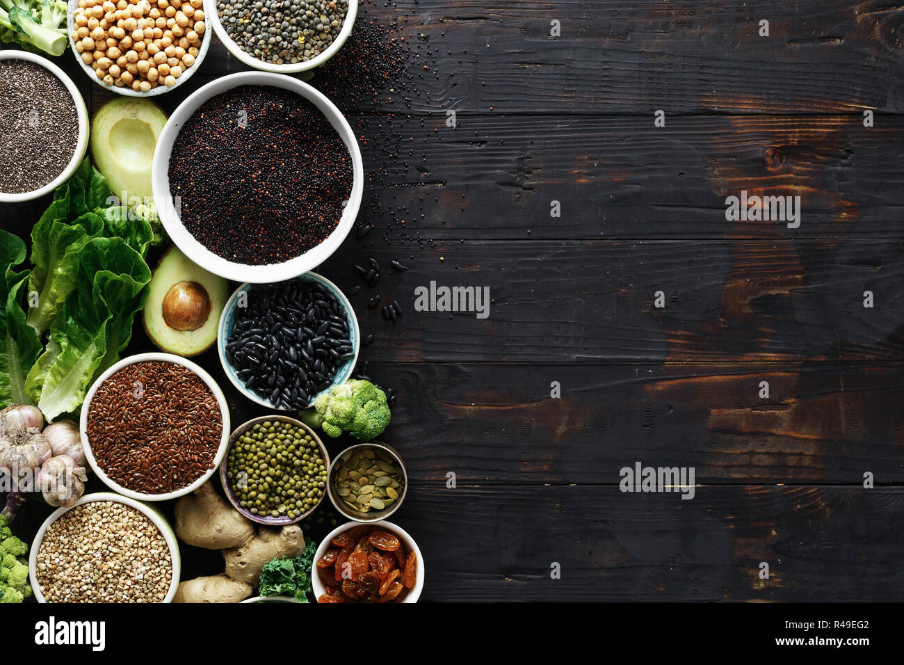 Set superfoods on dark wooden table with copy space. Leaves, cereals ...