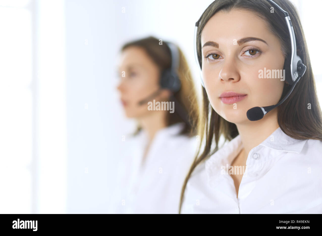 Group of call center operators at work. Focus on beautiful business woman in headset Stock Photo ...