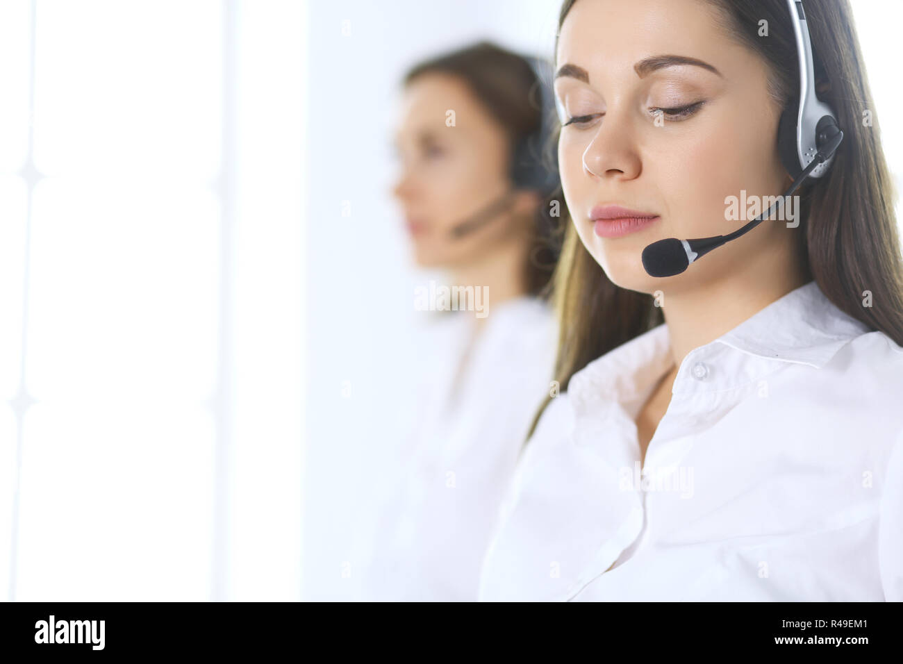 Group of call center operators at work. Focus on beautiful business woman in headset Stock Photo ...