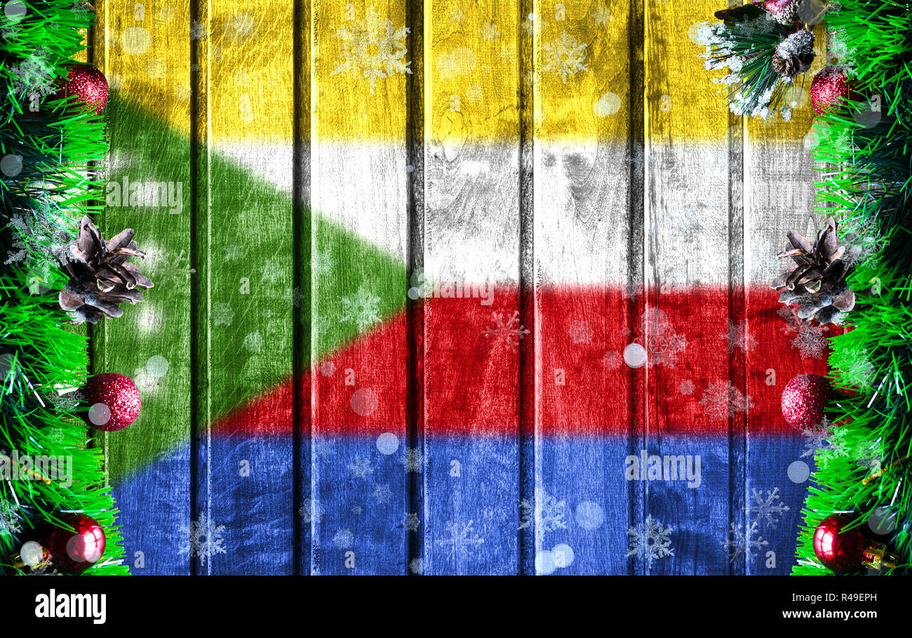 Wooden Christmas background with blurred flag of Comoros. There is a ...