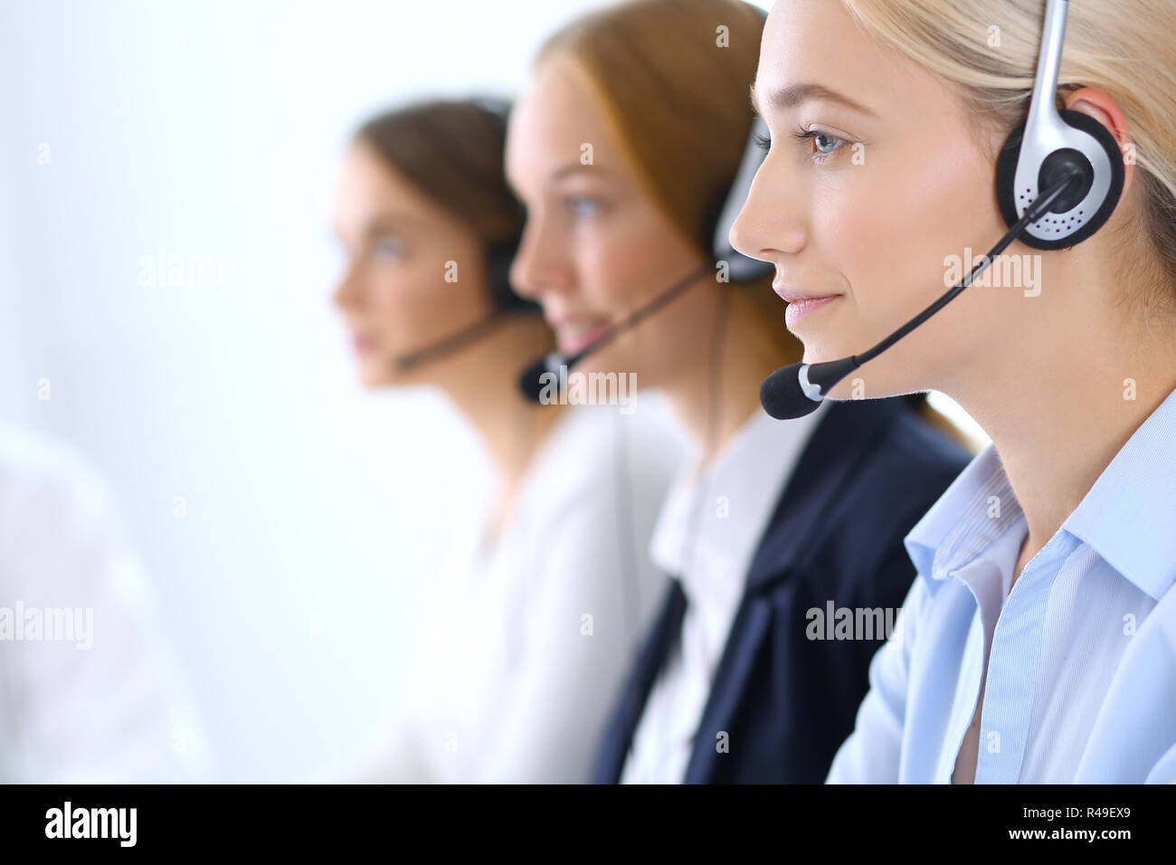 Call center. Group of operators at work. Focus at blonde business woman ...