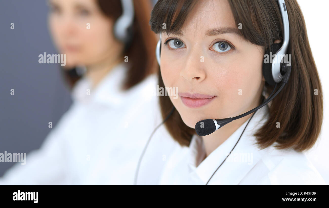 Call center. Group of operators at work. Focus on young brunette woman. Business concept Stock ...