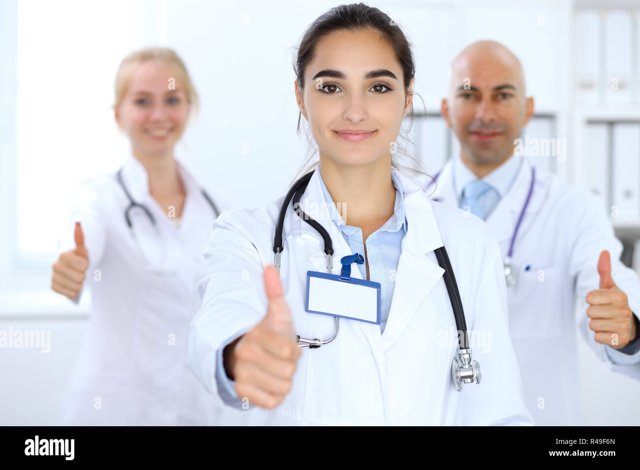 Group of doctors showing OK or approval sign with thumb up. High level ...