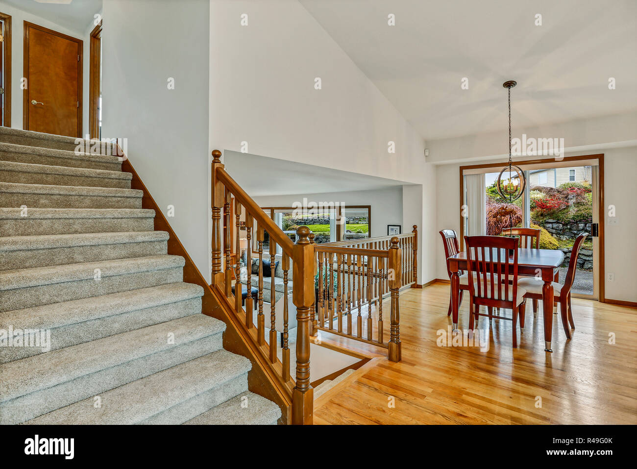 Traditional staircase and high vaulted ceiling with view of dining room ...