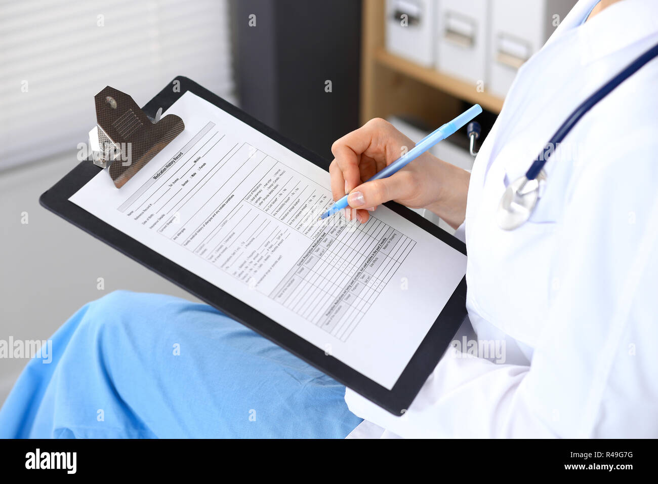 Woman doctor at work at hospital. Young female physician write ...