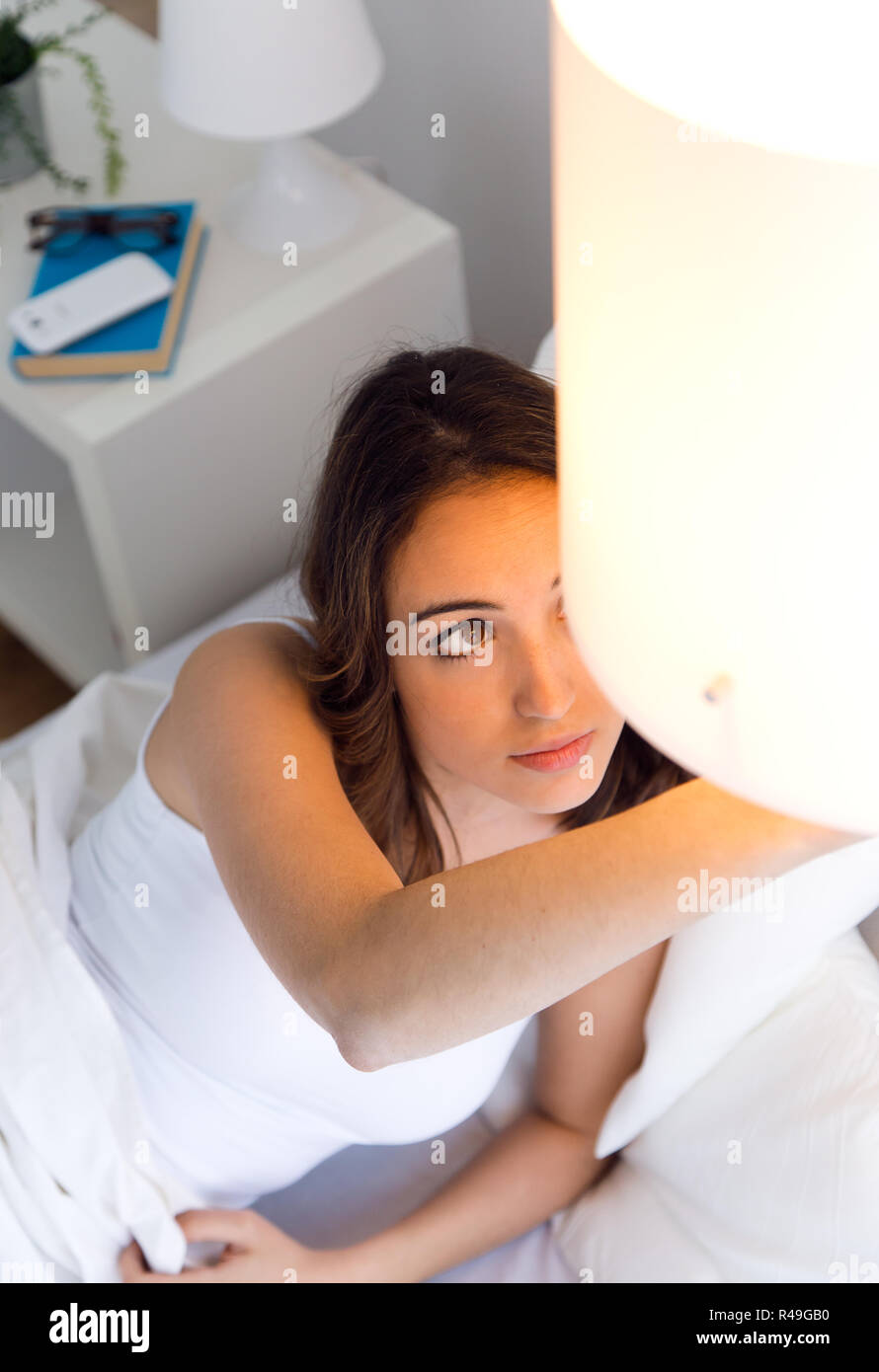 Beautiful young woman turning off the lamp Stock Photo - Alamy