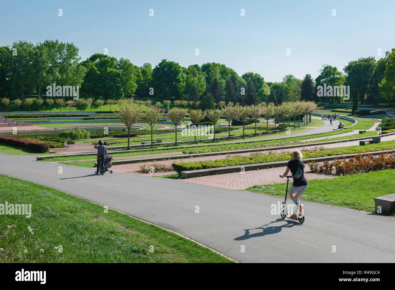 Citadel Park Poznan, view of a woman riding a scooter through the rose ...