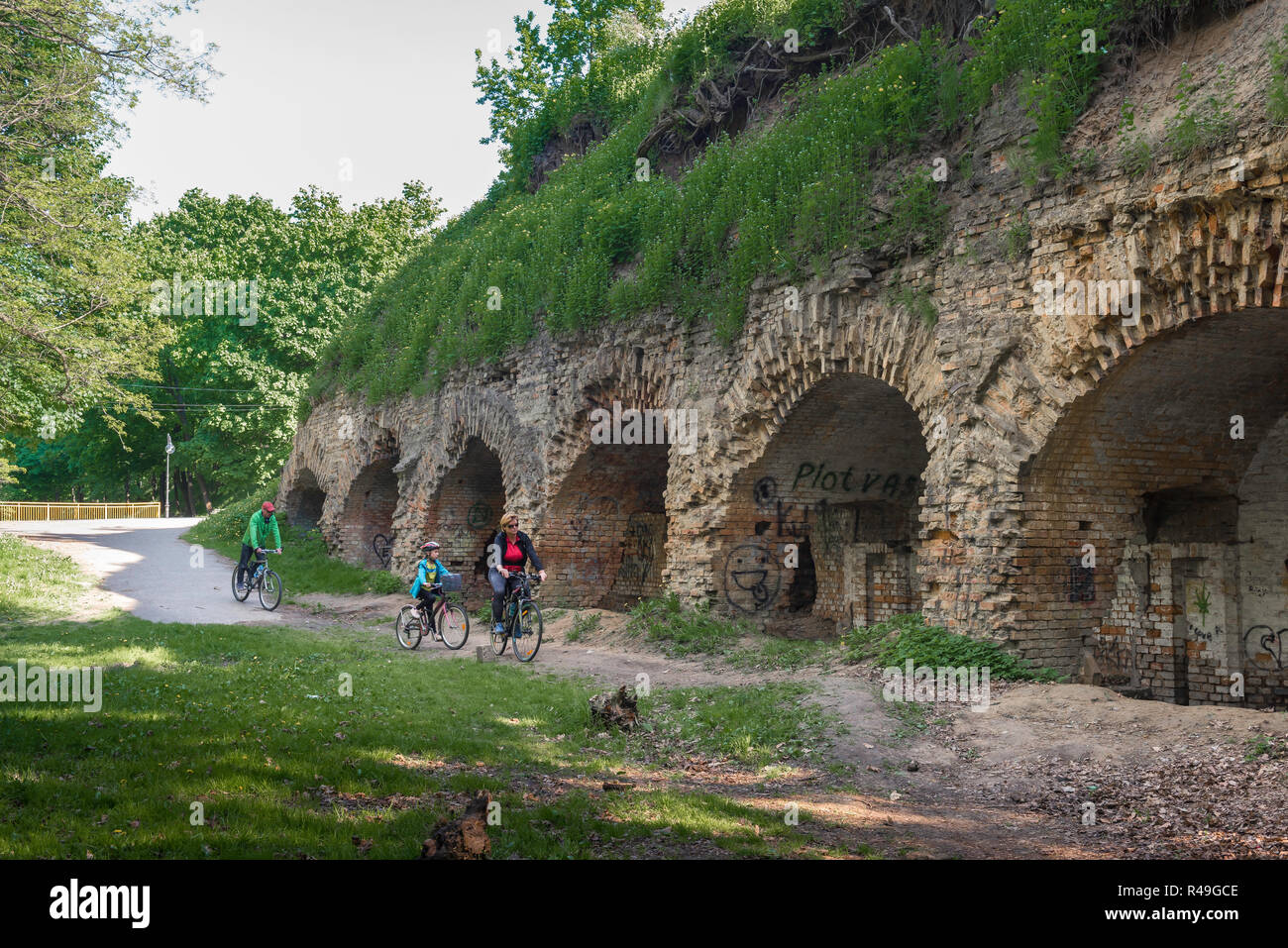 Citadel Park Poznan, view of a Polish family cycling past a ruined ...