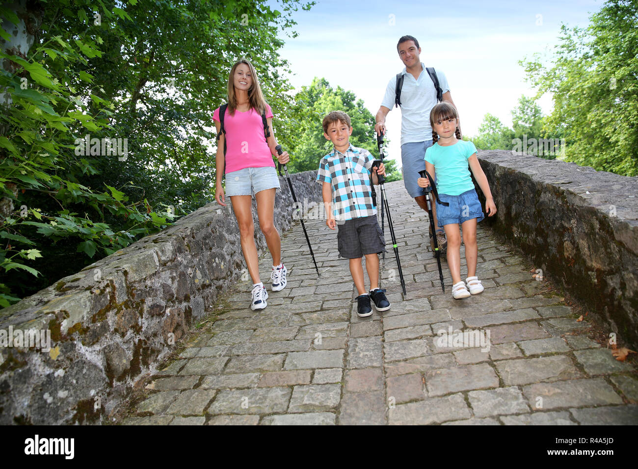 Family on a rambling journey crossing roman bridge Stock Photo - Alamy