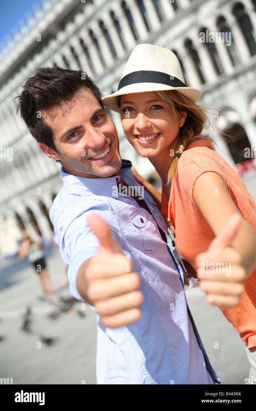 Cheerful couple showing thumbs up on San Marco Place Stock Photo - Alamy