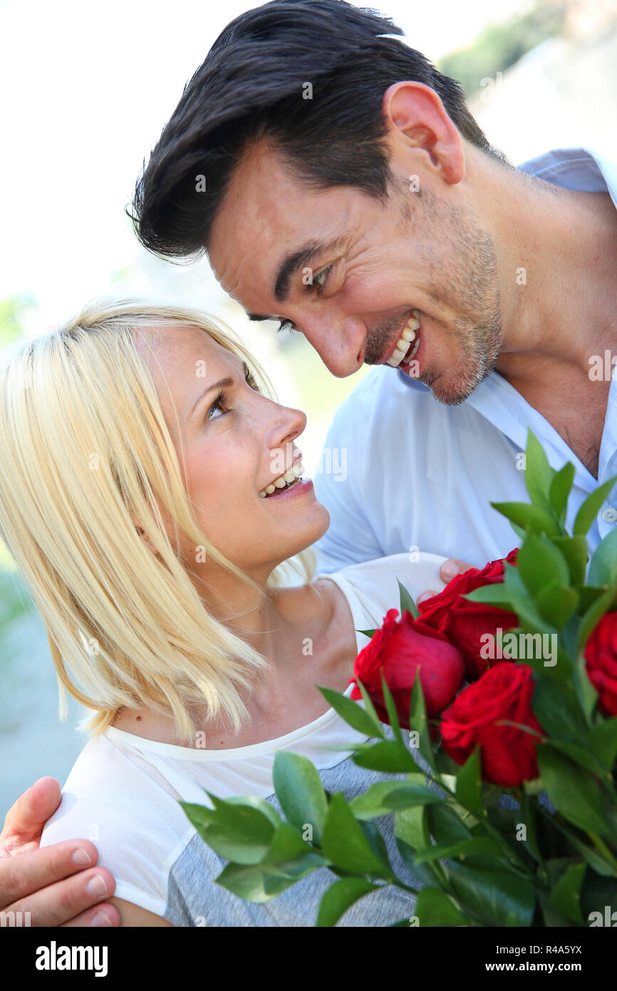 Man giving red roses to woman Stock Photo - Alamy