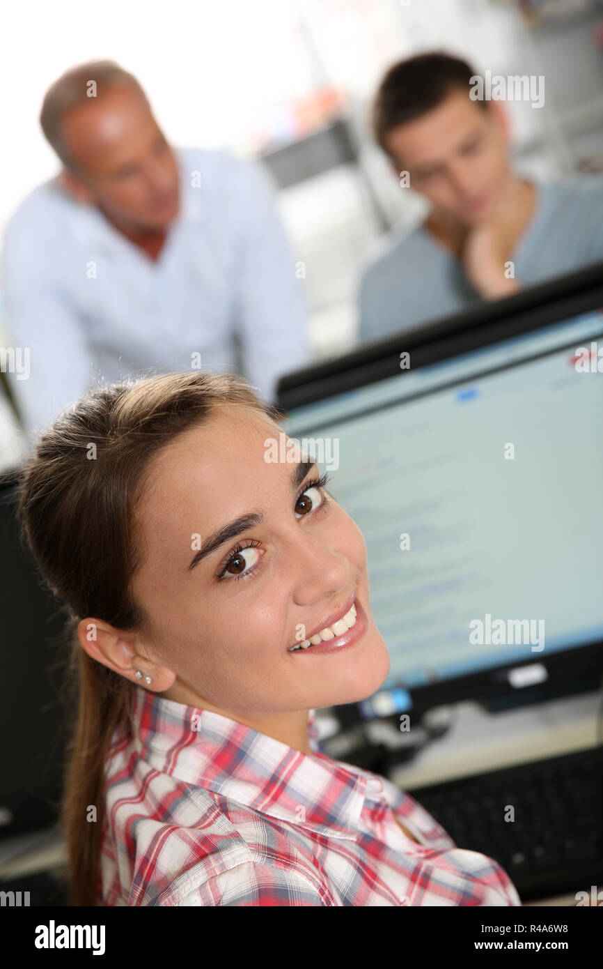 Smiling student girl in front of desktop Stock Photo - Alamy