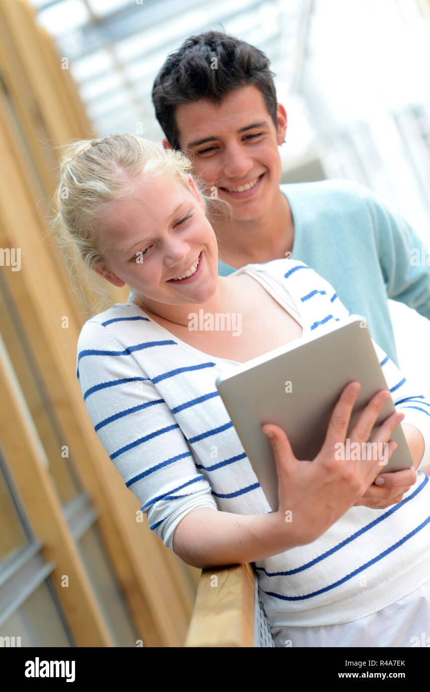 Teenagers using digital tablet at school Stock Photo - Alamy