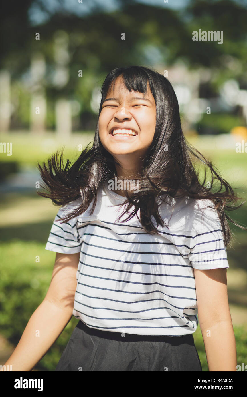kidding face of asian teenager showns forelock hair flowing by wind ...