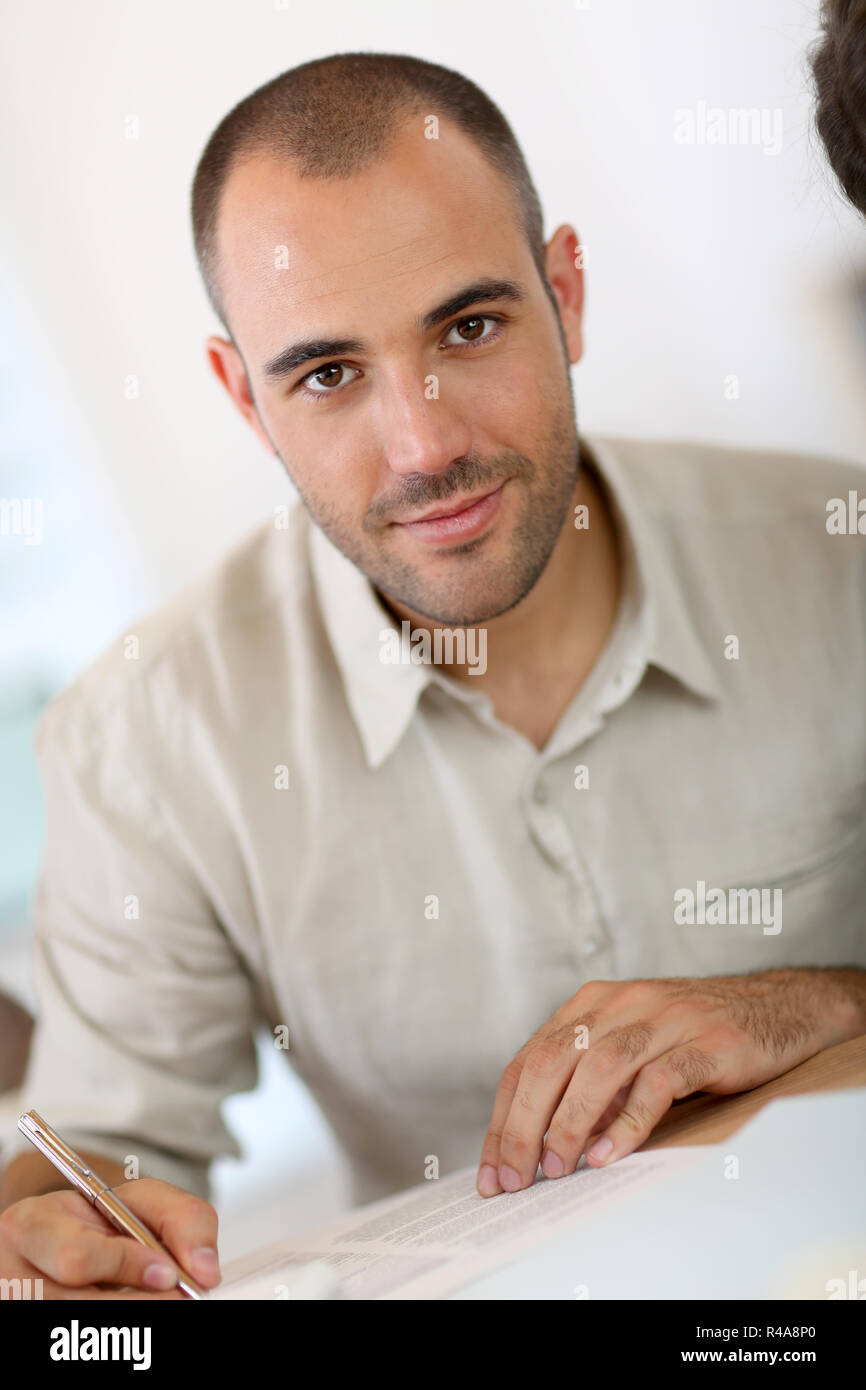 Portrait of young man filling in application form Stock Photo - Alamy