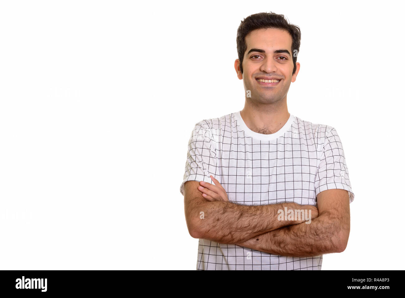 Portrait of young happy Persian man smiling with arms crossed Stock ...