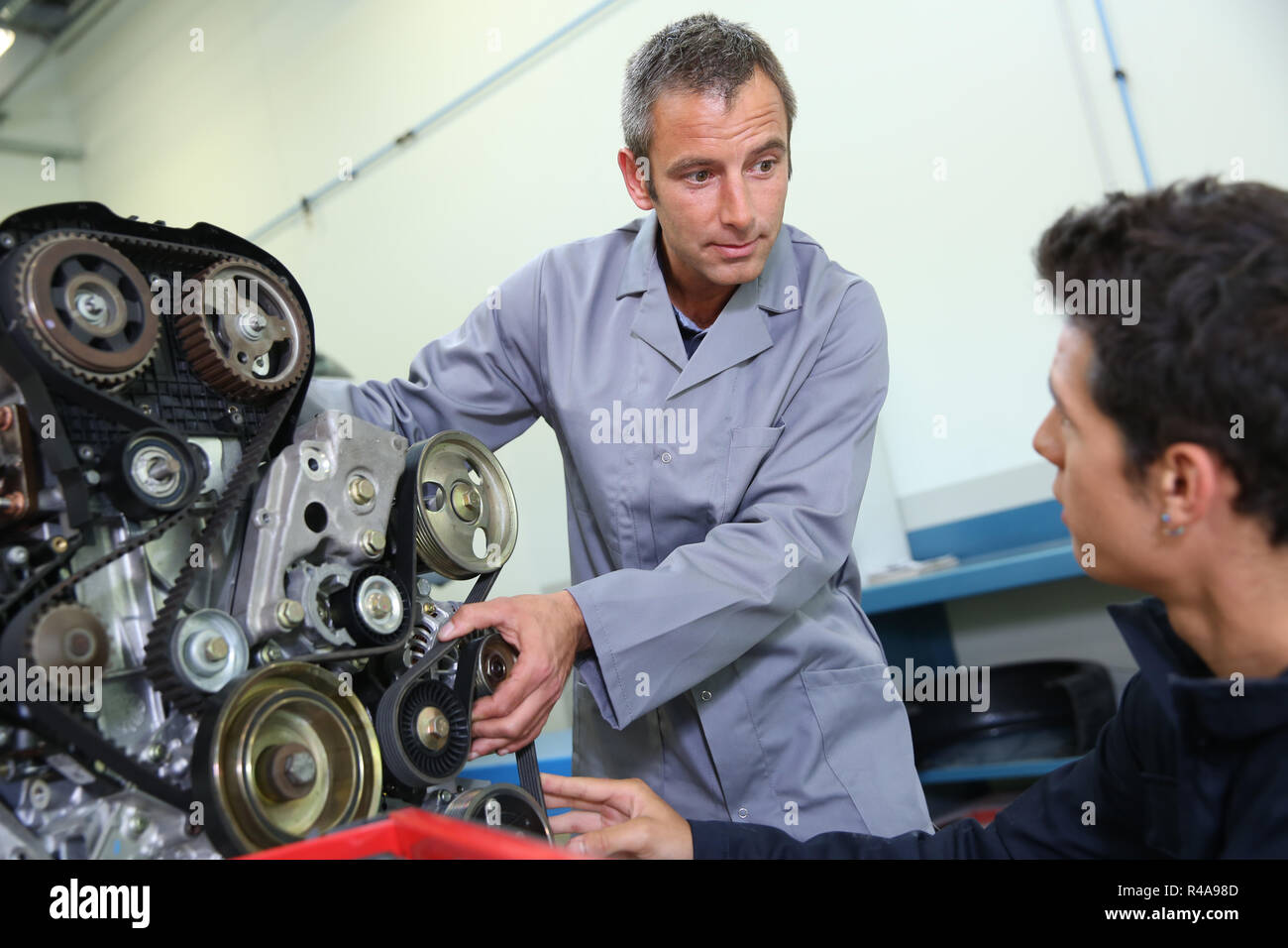 Professional trainer teaching student how to fix car engine Stock Photo ...
