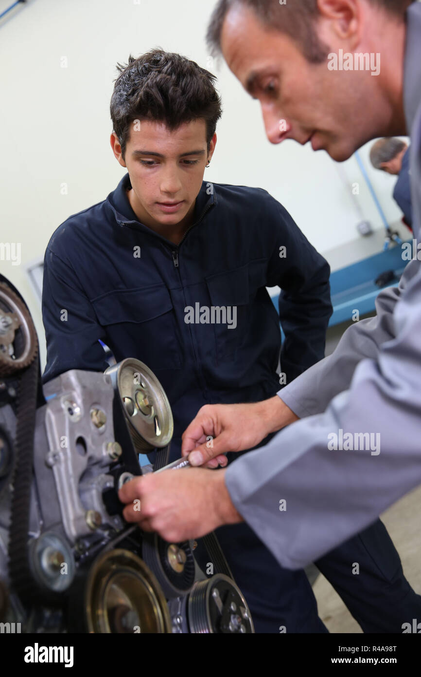 Professional trainer teaching student how to fix car engine Stock Photo ...