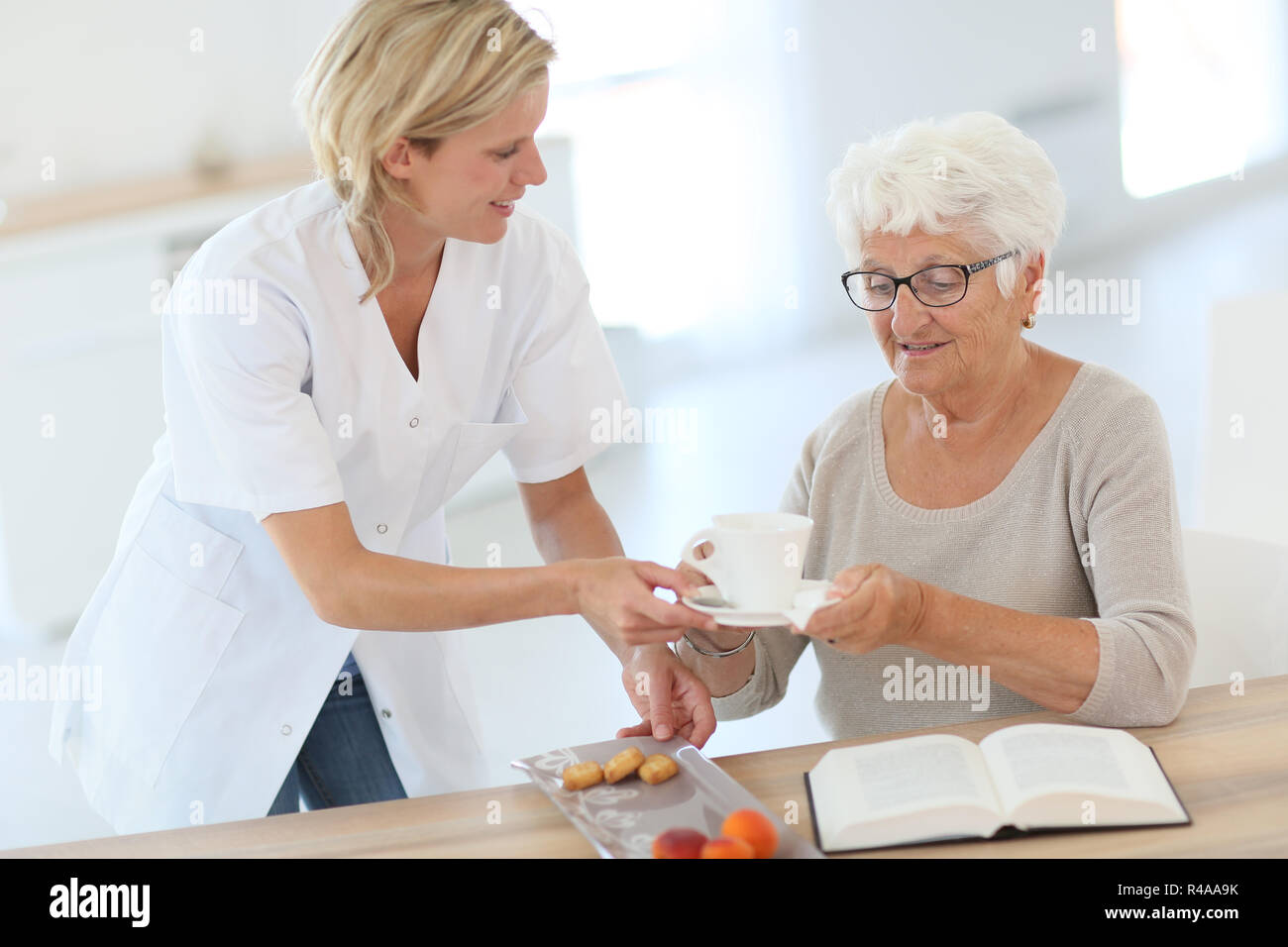Woman giving tea older woman hi-res stock photography and images - Alamy