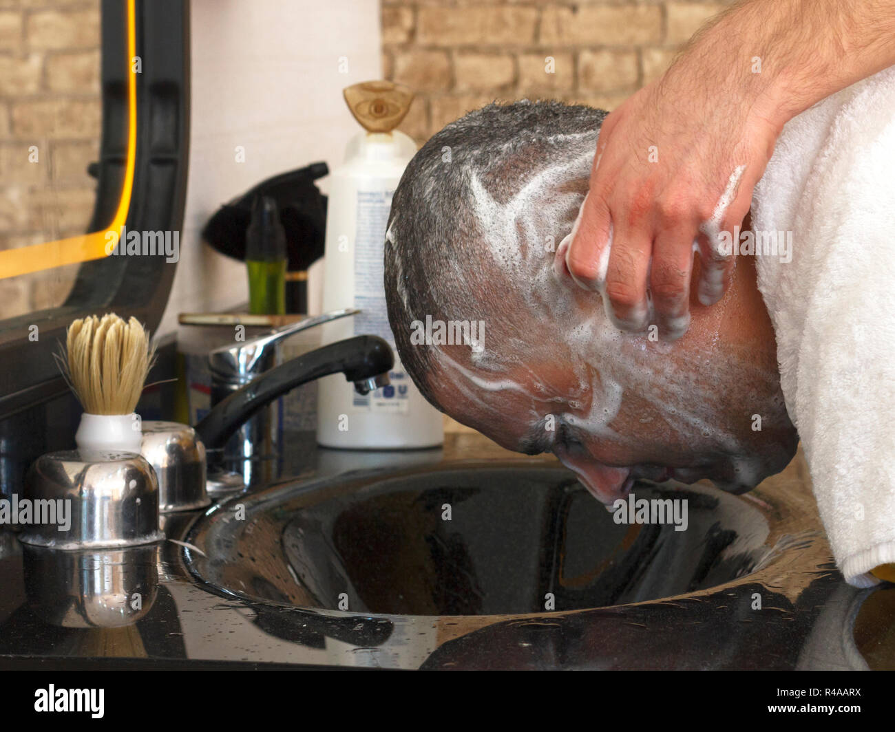 Hairdresser washing hair to turkish man after haircut in barber shop ...