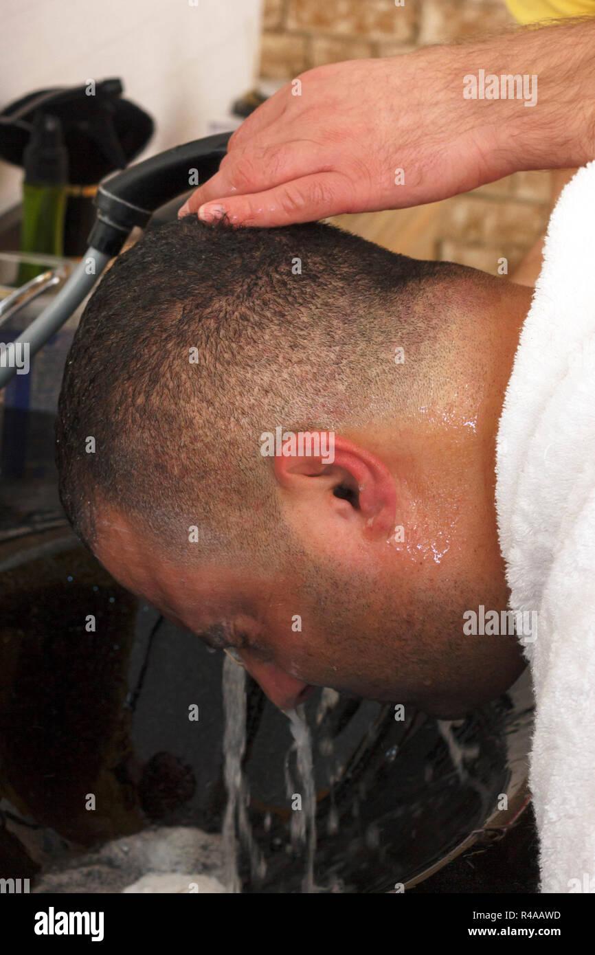 Hairdresser washing hair to turkish man after haircut in barber shop ...