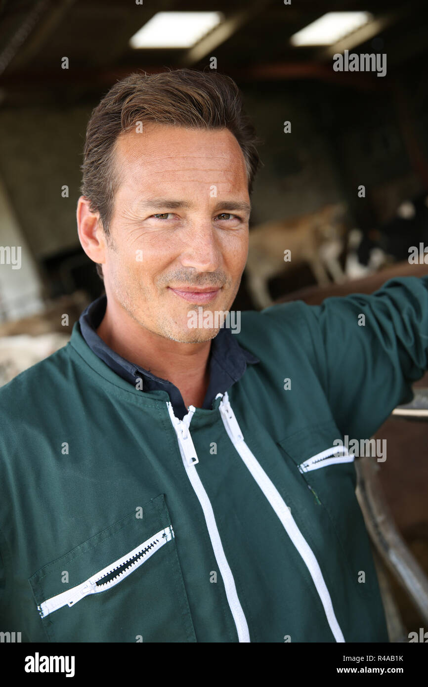 Smiling farmer standing in barn Stock Photo - Alamy