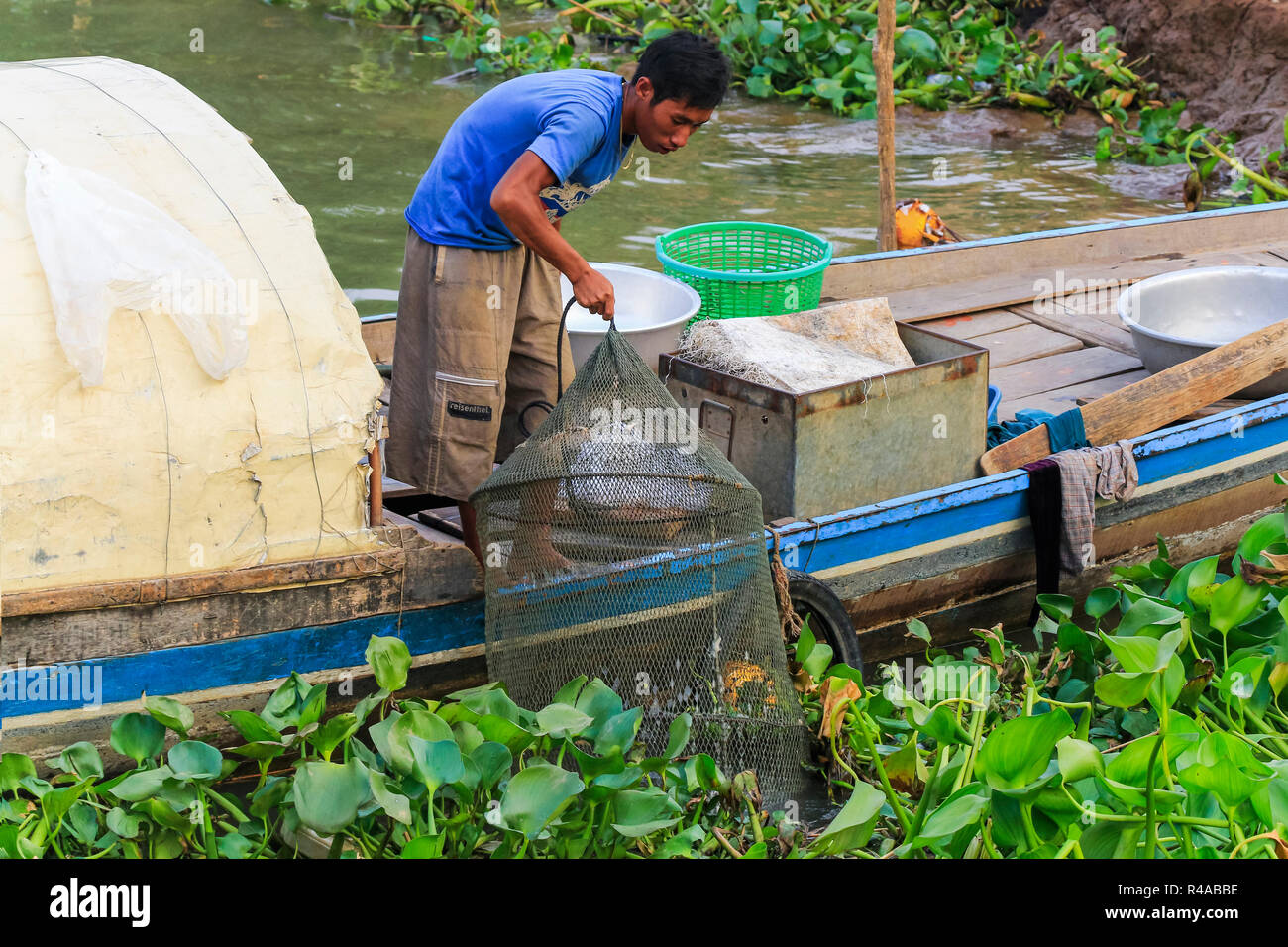 Man of the Muslim Cham fishing people that live on boats, with catfish ...