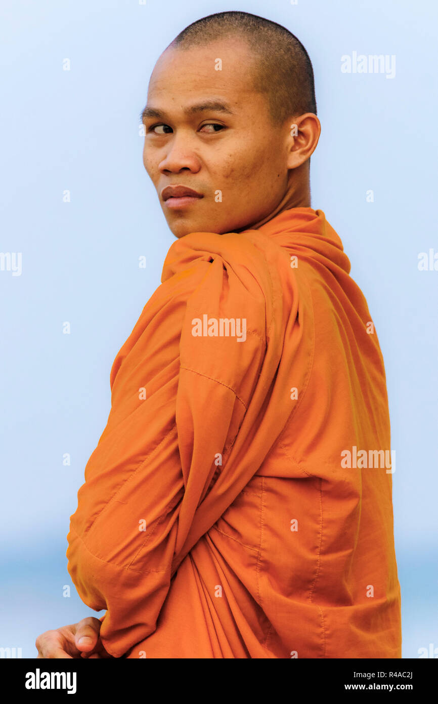 Young Buddhist monk in robe on the Mekong riverfront promenade at ...