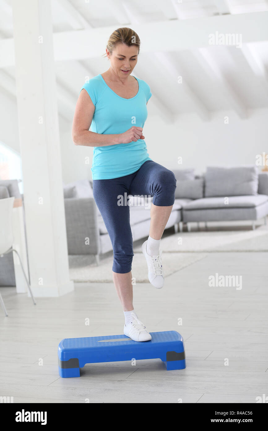 Middle-aged woman doing step exercices at home Stock Photo - Alamy