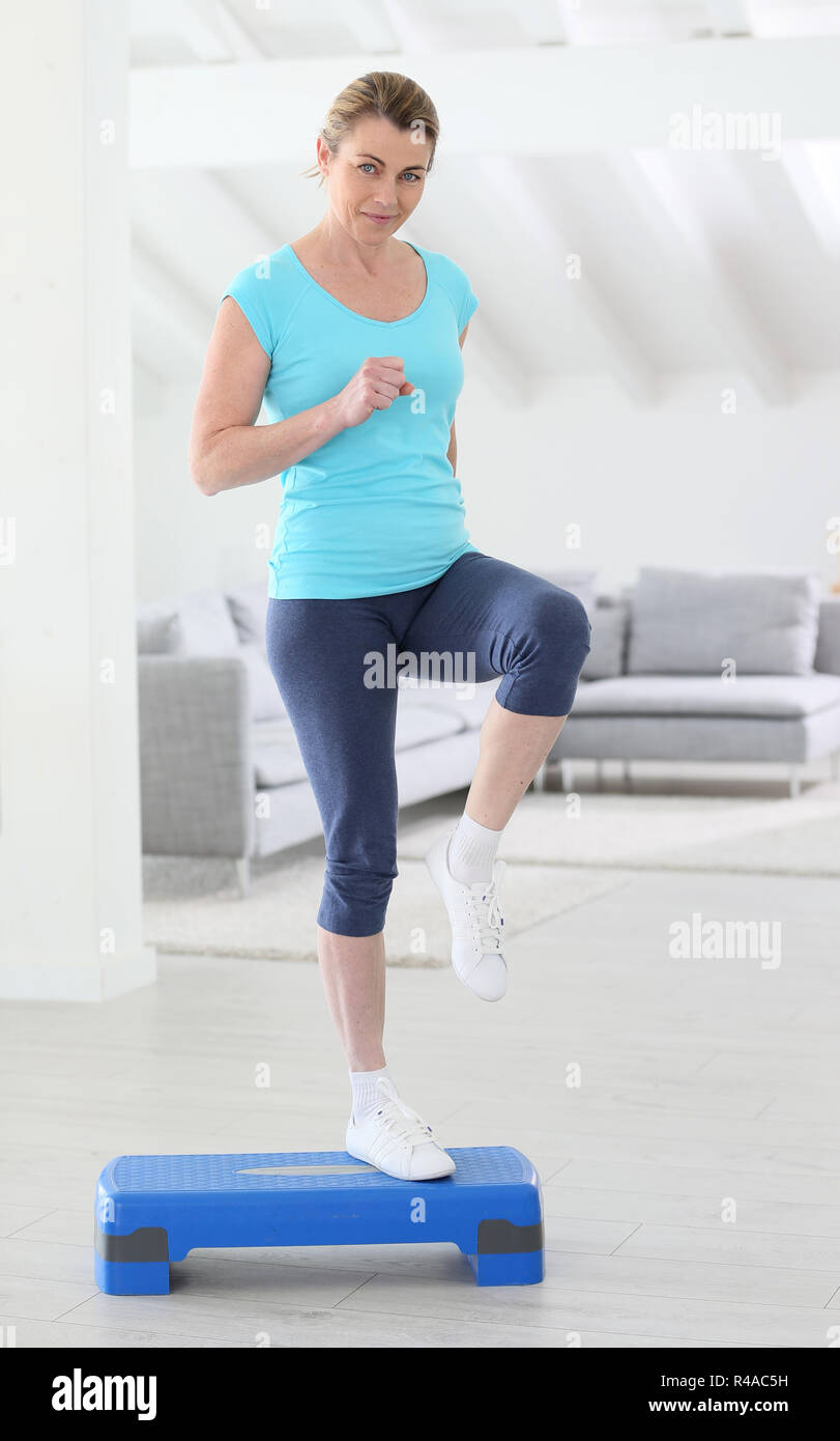 Middle-aged woman doing step exercices at home Stock Photo - Alamy