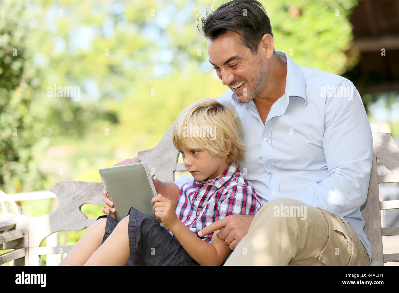 Daddy and son playing with tablet outside Stock Photo - Alamy