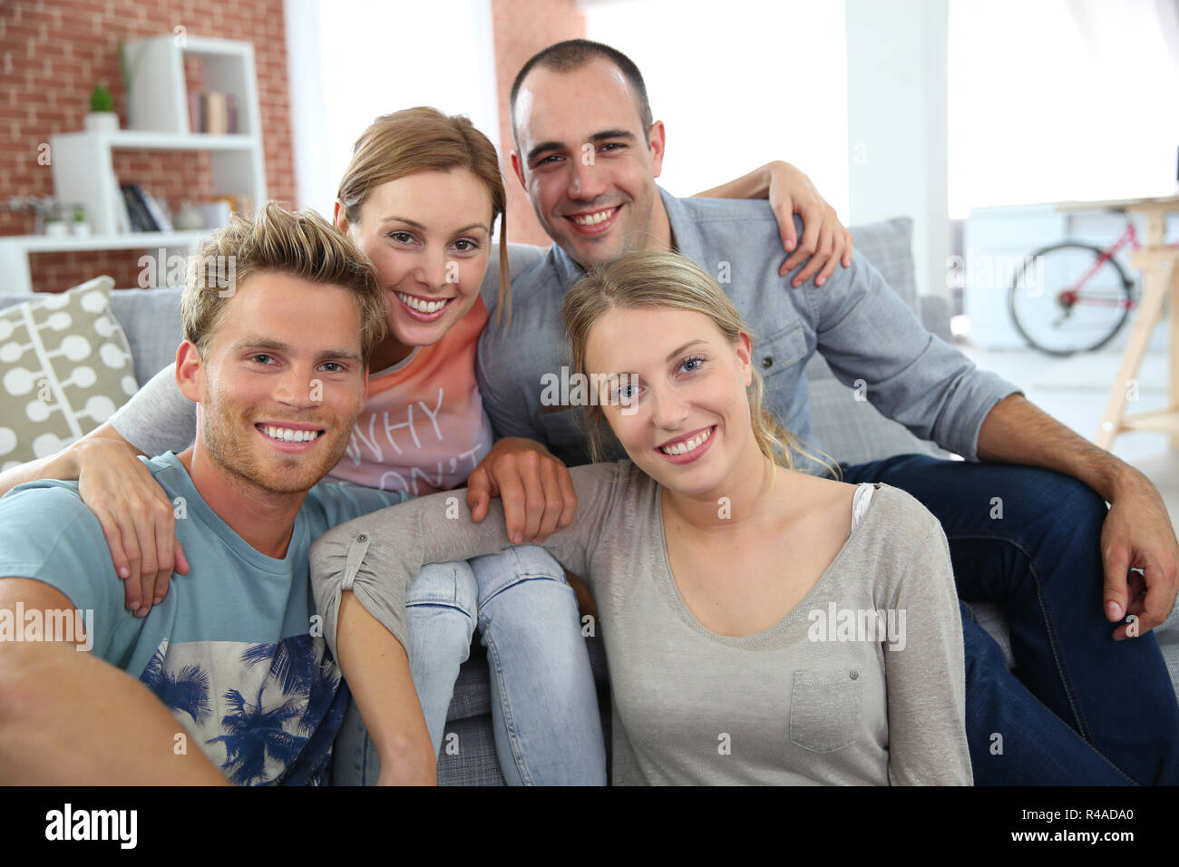 Roommates sitting together in couch Stock Photo - Alamy