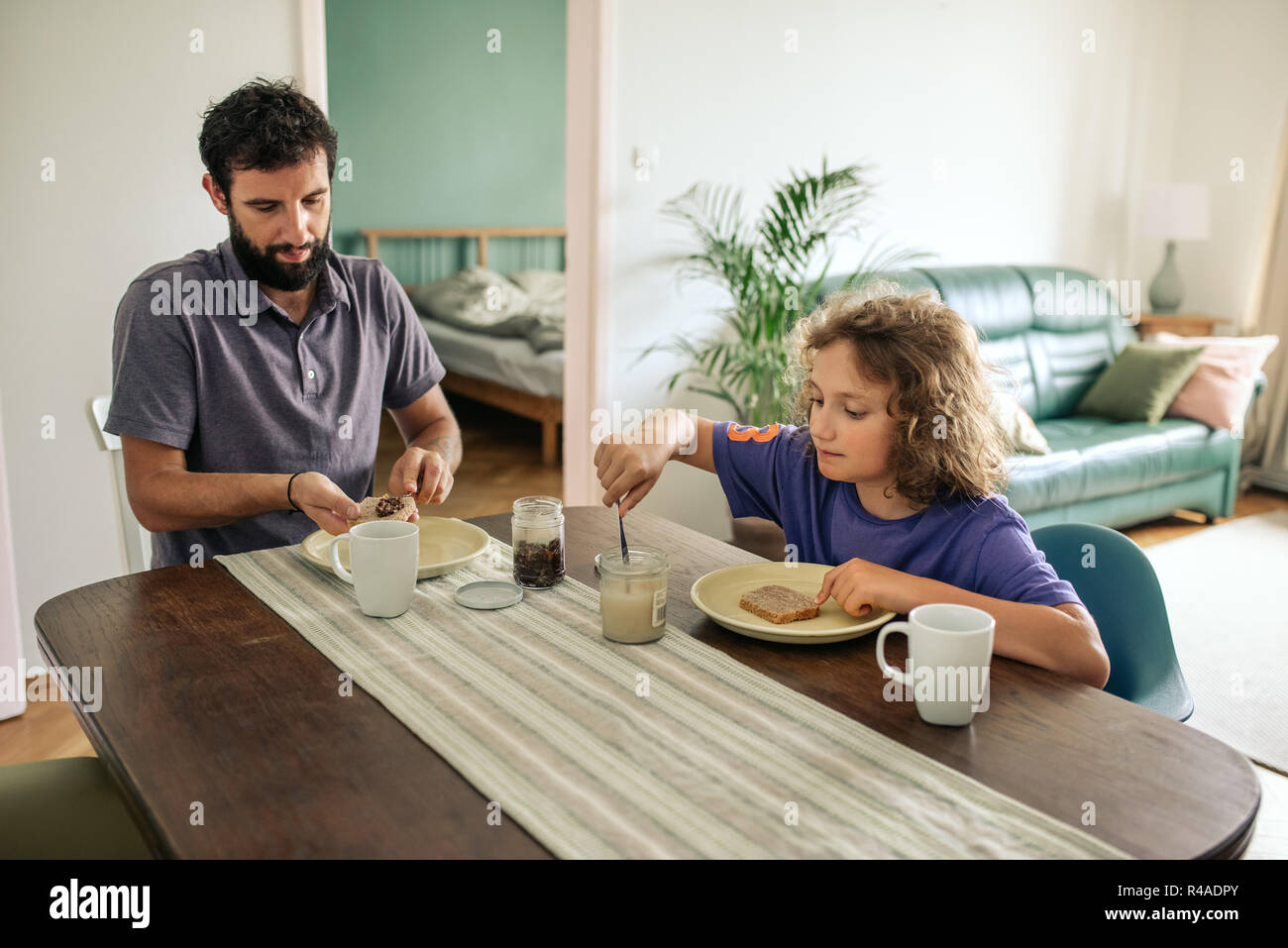 Father and young son eating lunch together at home Stock Photo - Alamy