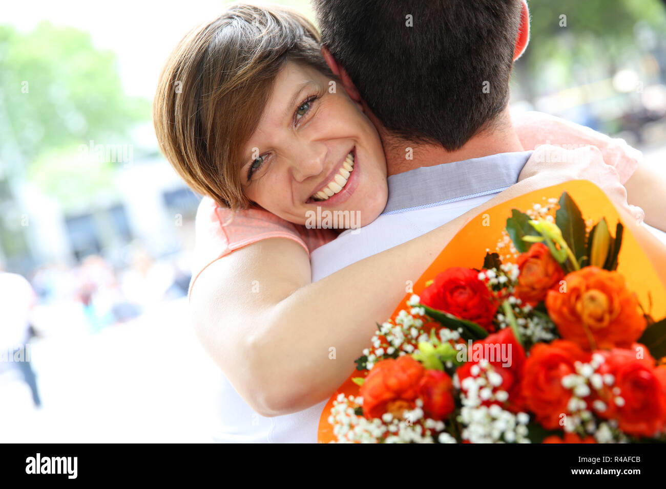 Portrait of cheerful girl holding bunch of flowers Stock Photo - Alamy