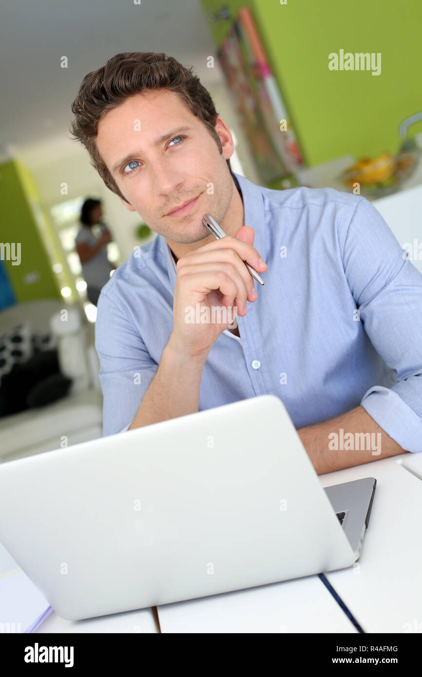 Man in front of laptop with thoughtful look Stock Photo - Alamy