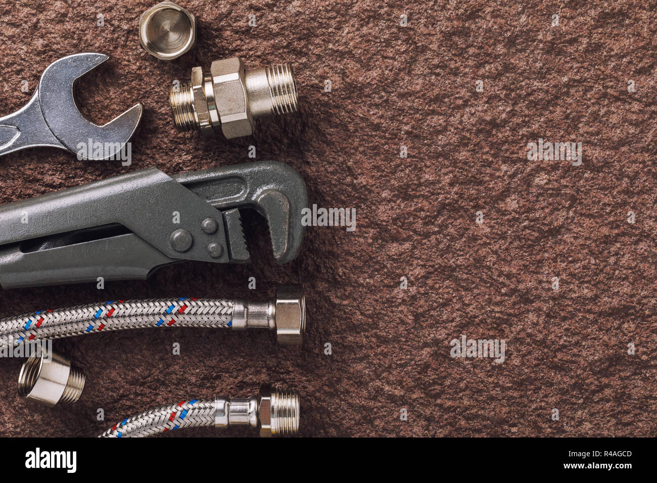 Set of tools for plumbing on a stone surface with copy space, top view ...