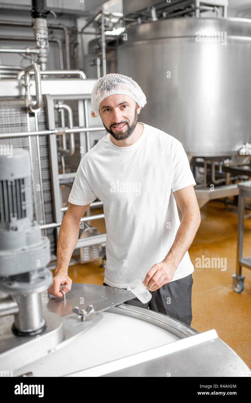 Worker adding supplements during the milk fermentation process in the ...
