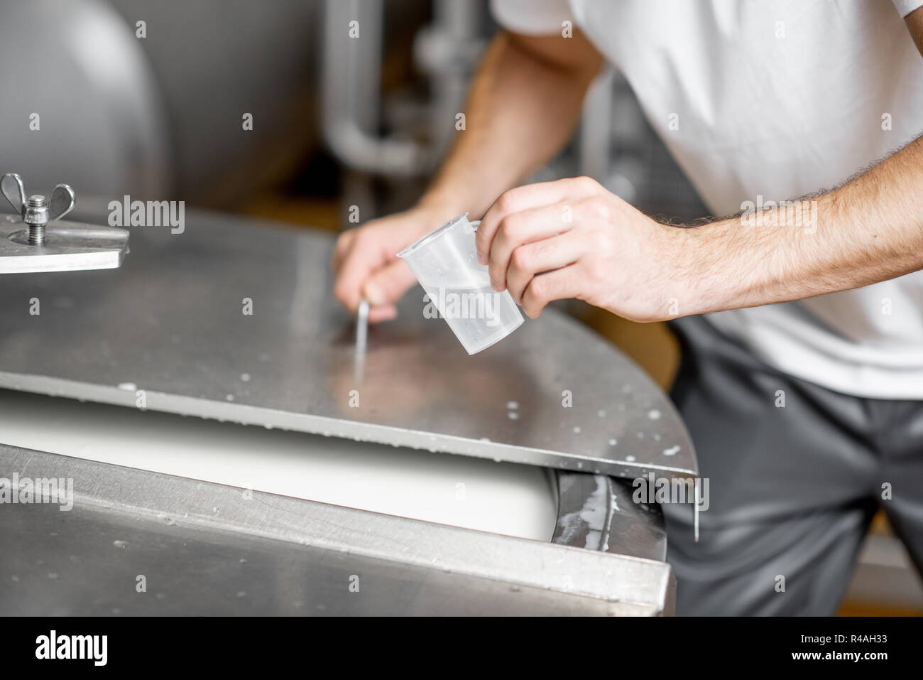 Worker adding supplements during the milk fermentation process in the ...