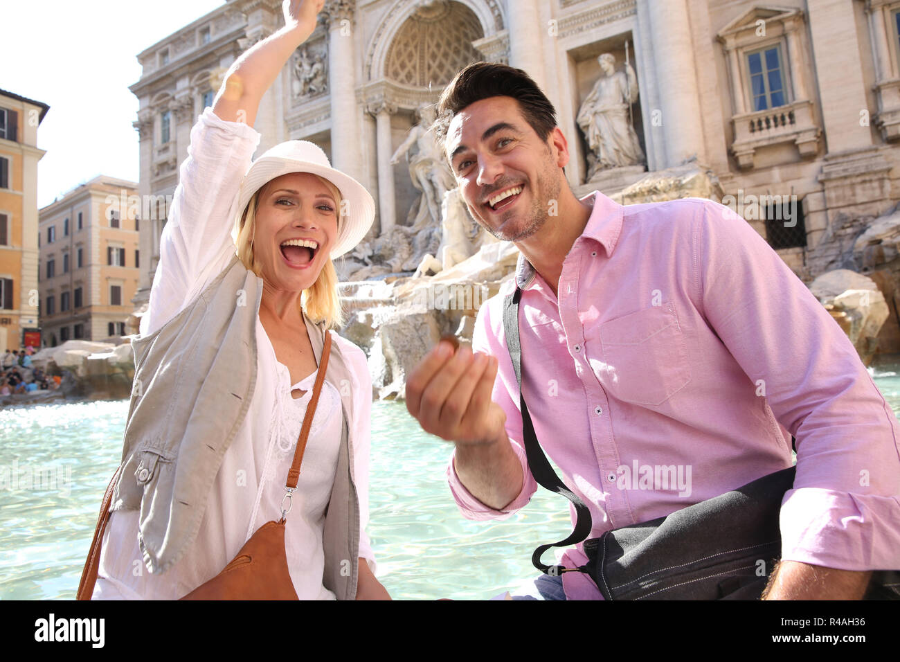 Couple of tourists throwing coins in Trevi fountain water Stock Photo ...