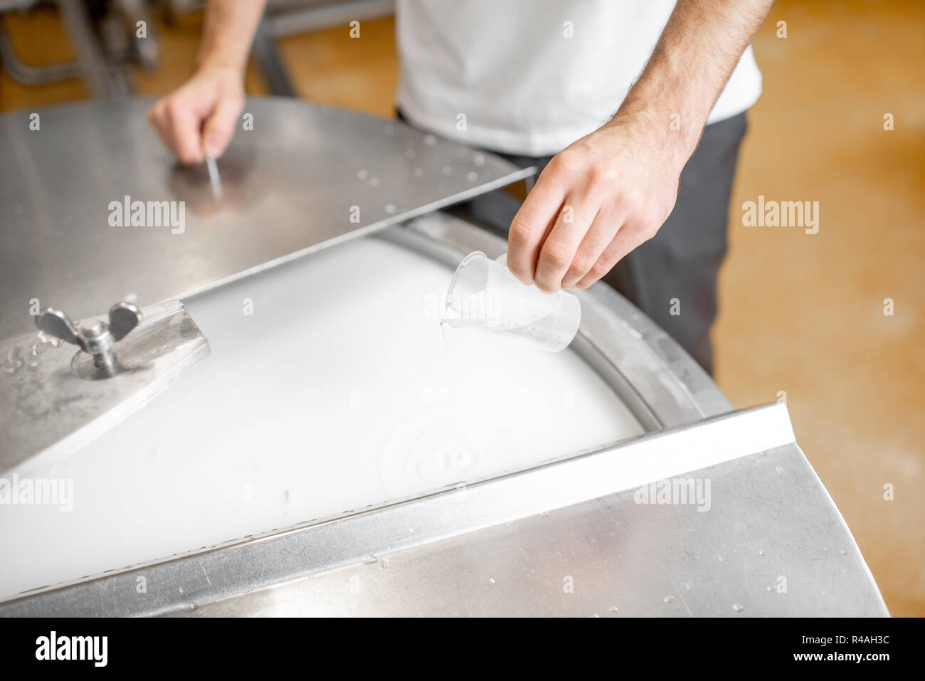 Worker adding supplements during the milk fermentation process in the ...